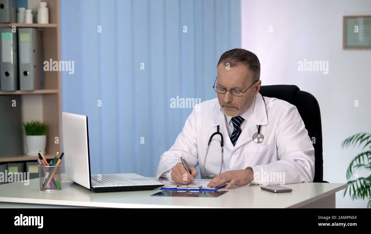 Doctor filling in medical record, considering diagnosis and treatment ...