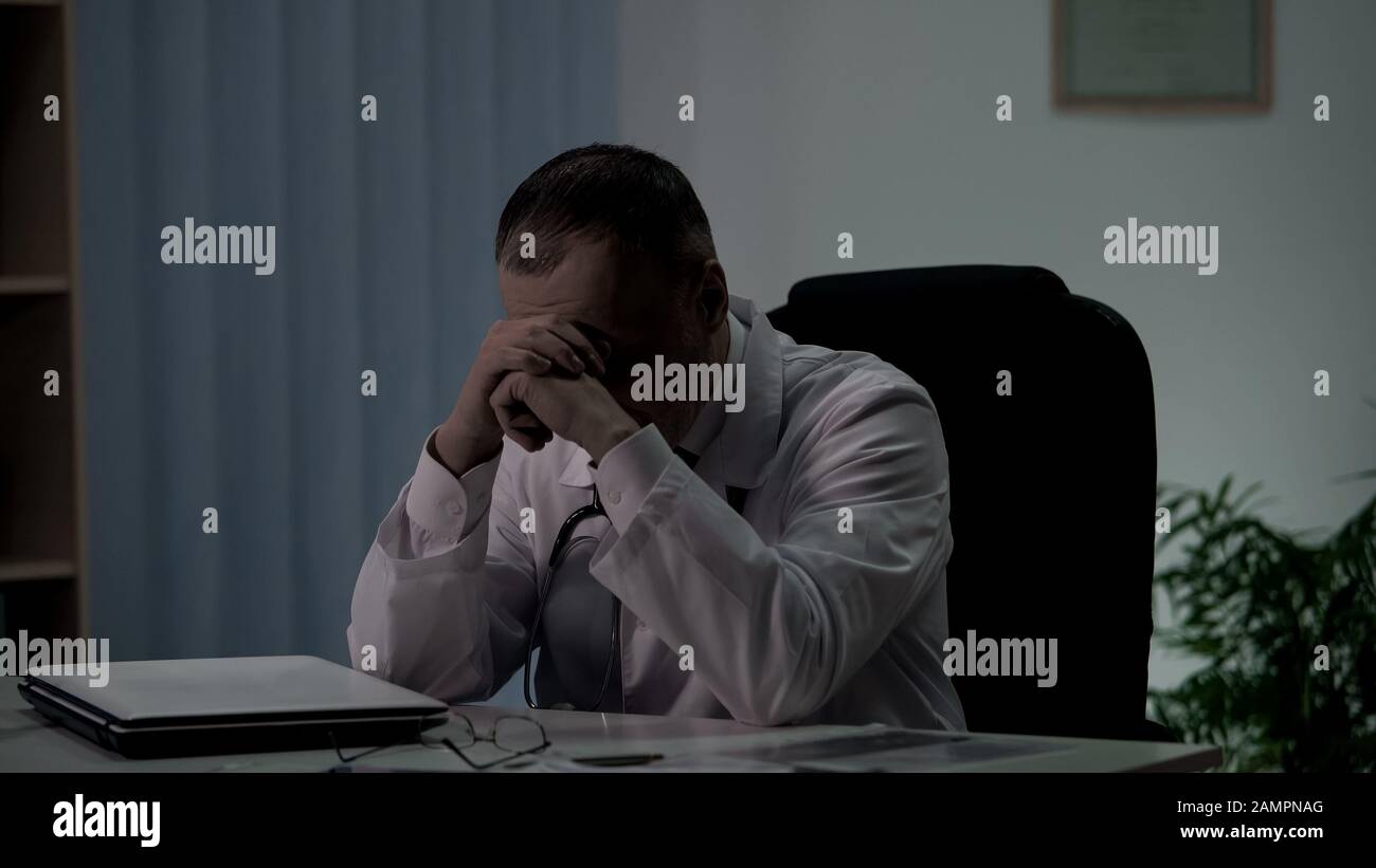 Overworked physician exhausted after day shift at hospital, workaholic ...