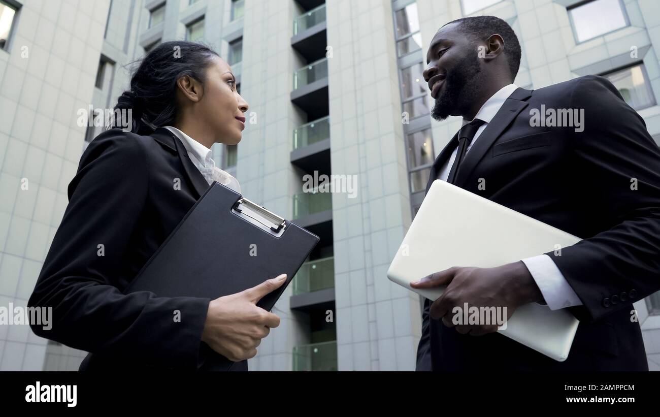 Company employees talking near office building, successful teamwork on ...