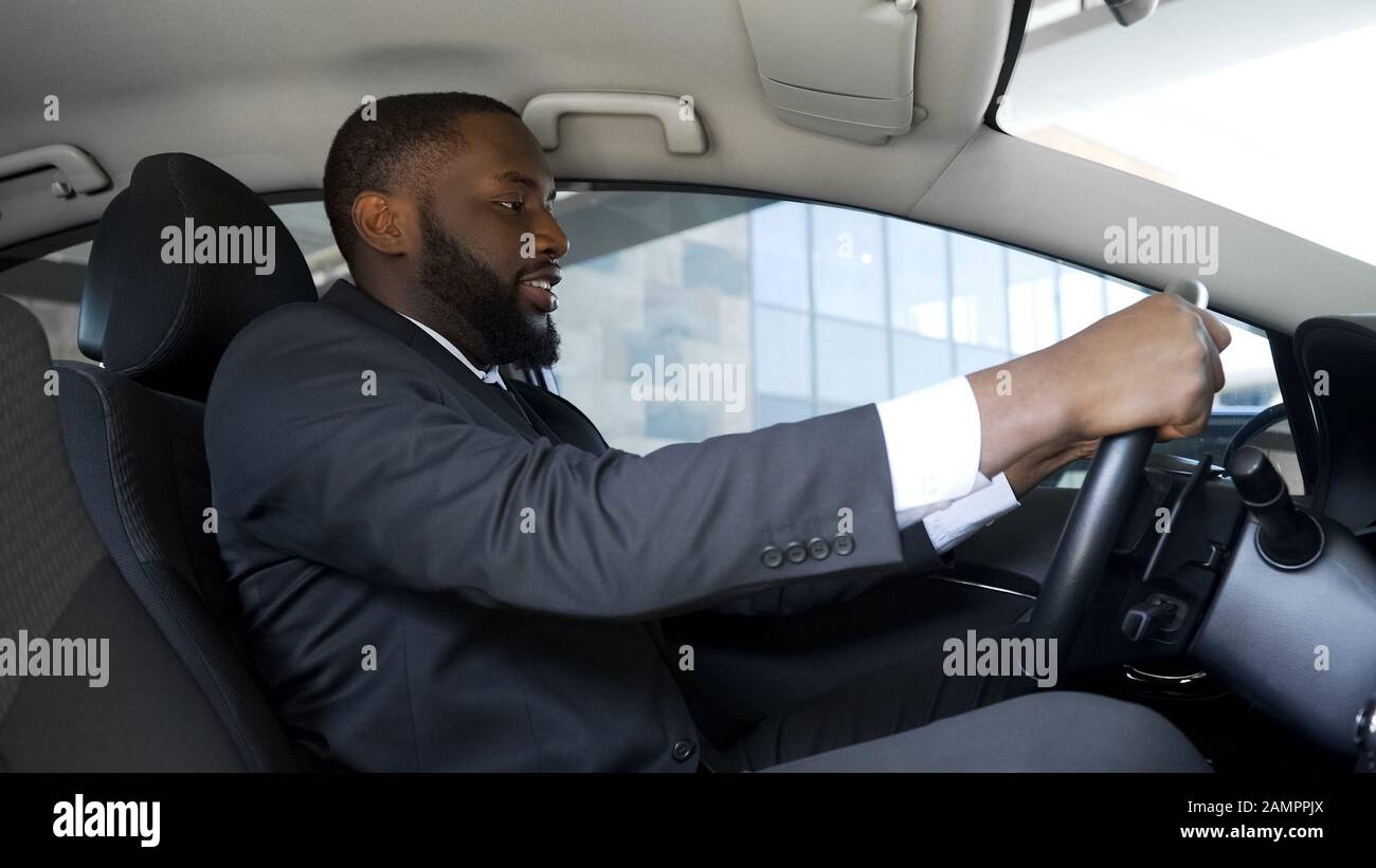 Happy man driving new car, excited by successful purchase, dreams come ...