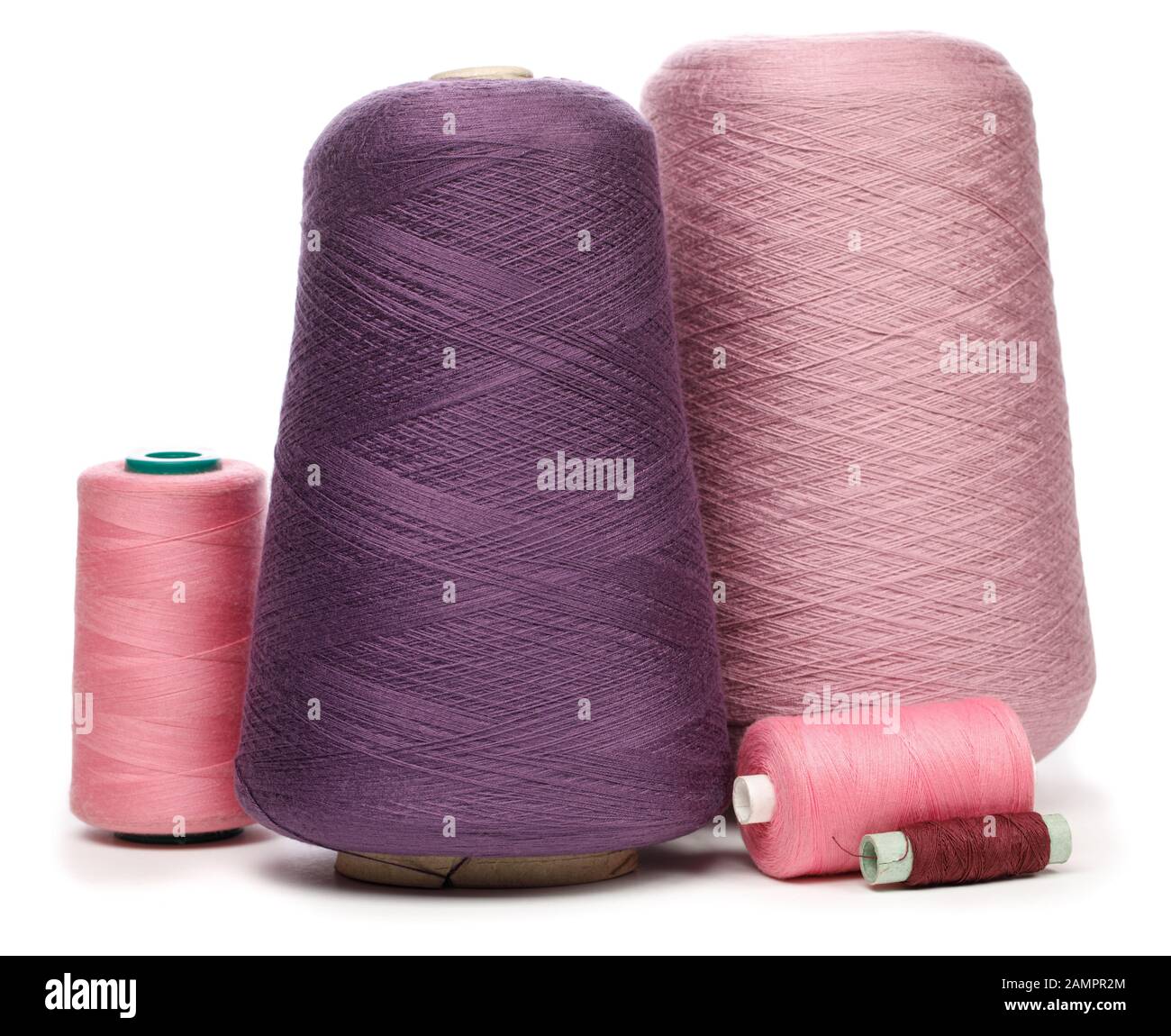 Group of cones and spools of pink purple and violet synthetic or cotton ...