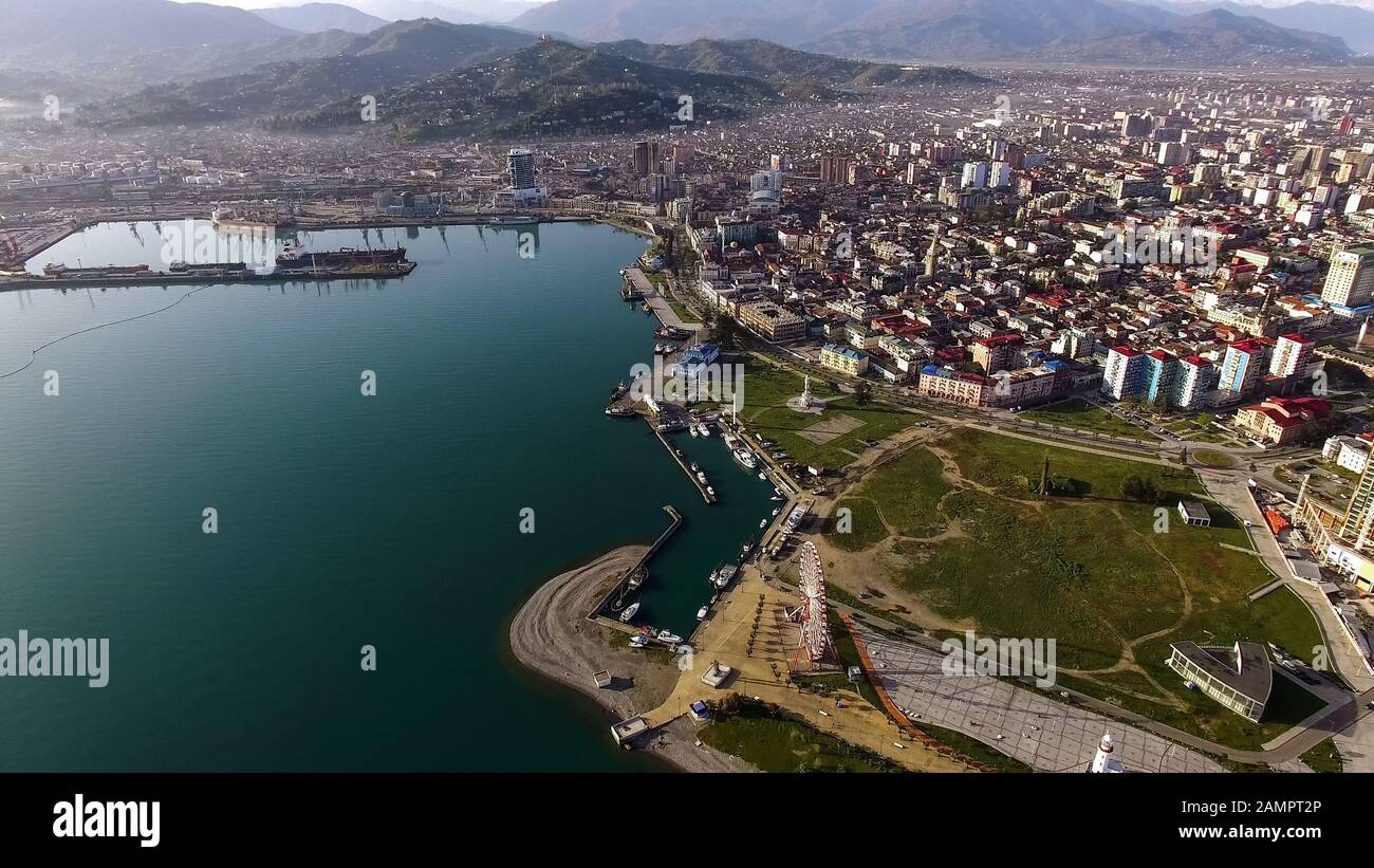 Modern city architecture on seashore with spectacular mountains, aerial ...