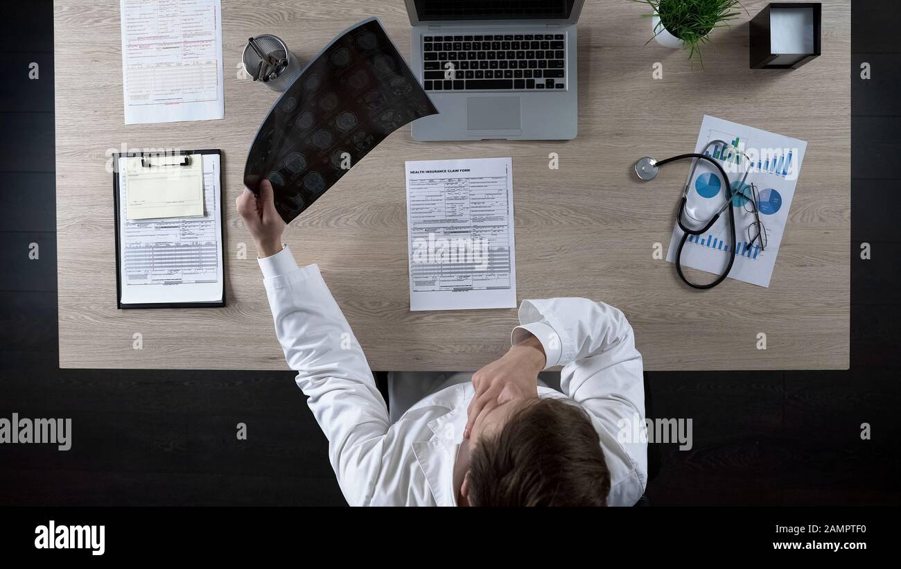 Top view of neurosurgeon diagnosing patient disease while looking at ...