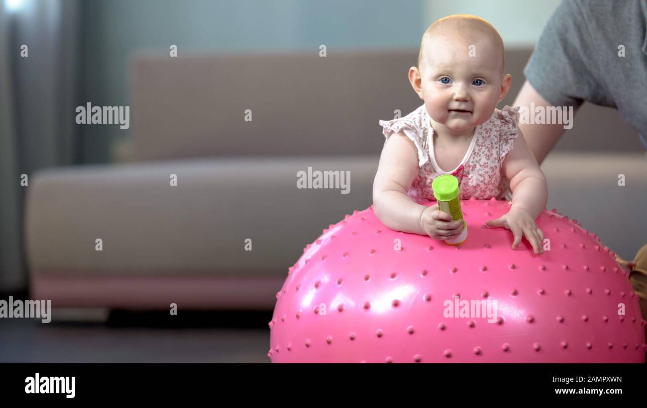 Cute healthy baby enjoying jumping on big ball, fitness exercises for ...