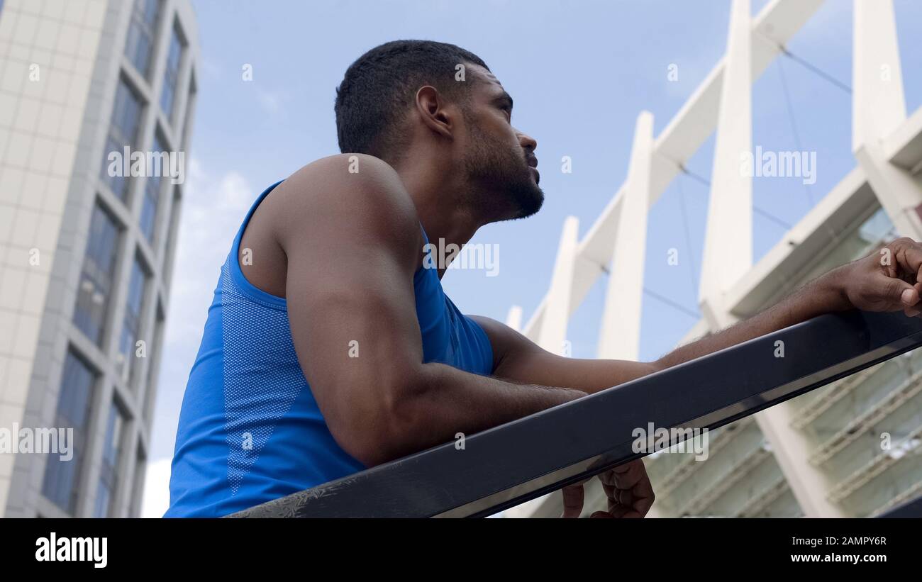 Tired handsome athlete having rest after training, working hard to ...