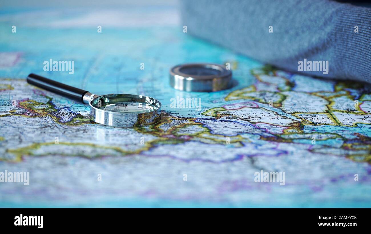 Magnifying glass and compass on map, adventure planning, vacation ...