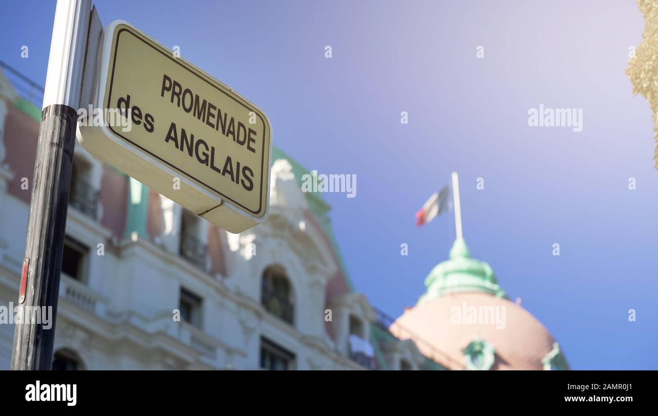 Promenade des Anglais street sign, French flag waving on top of ...
