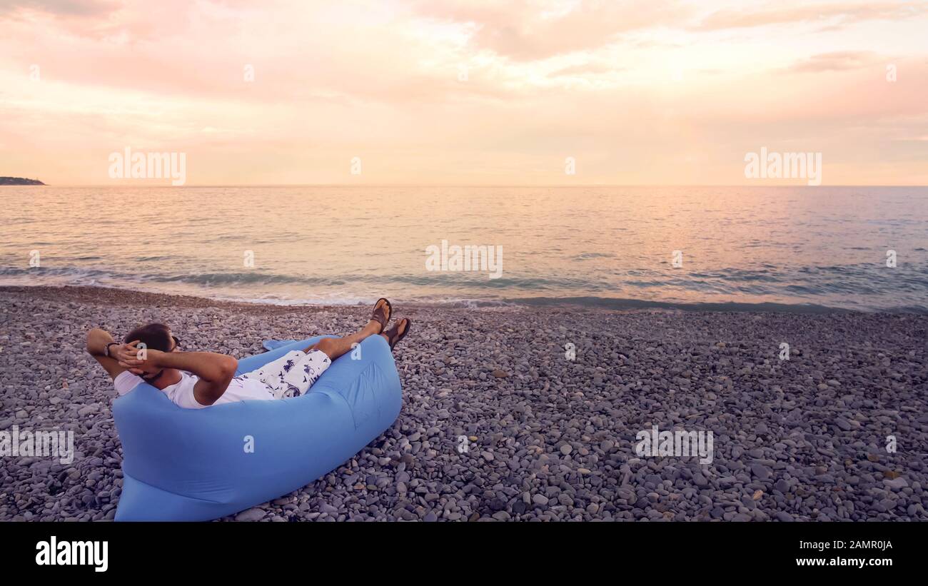 Free man relaxing on beach, enjoying seascape view, having rest on ...