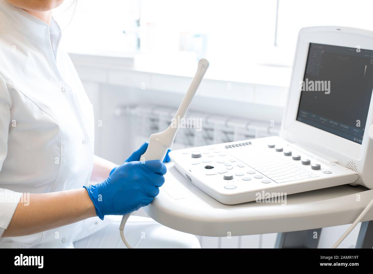 A gynecologist sets up an ultrasound machine. A transvaginal ultrasound ...