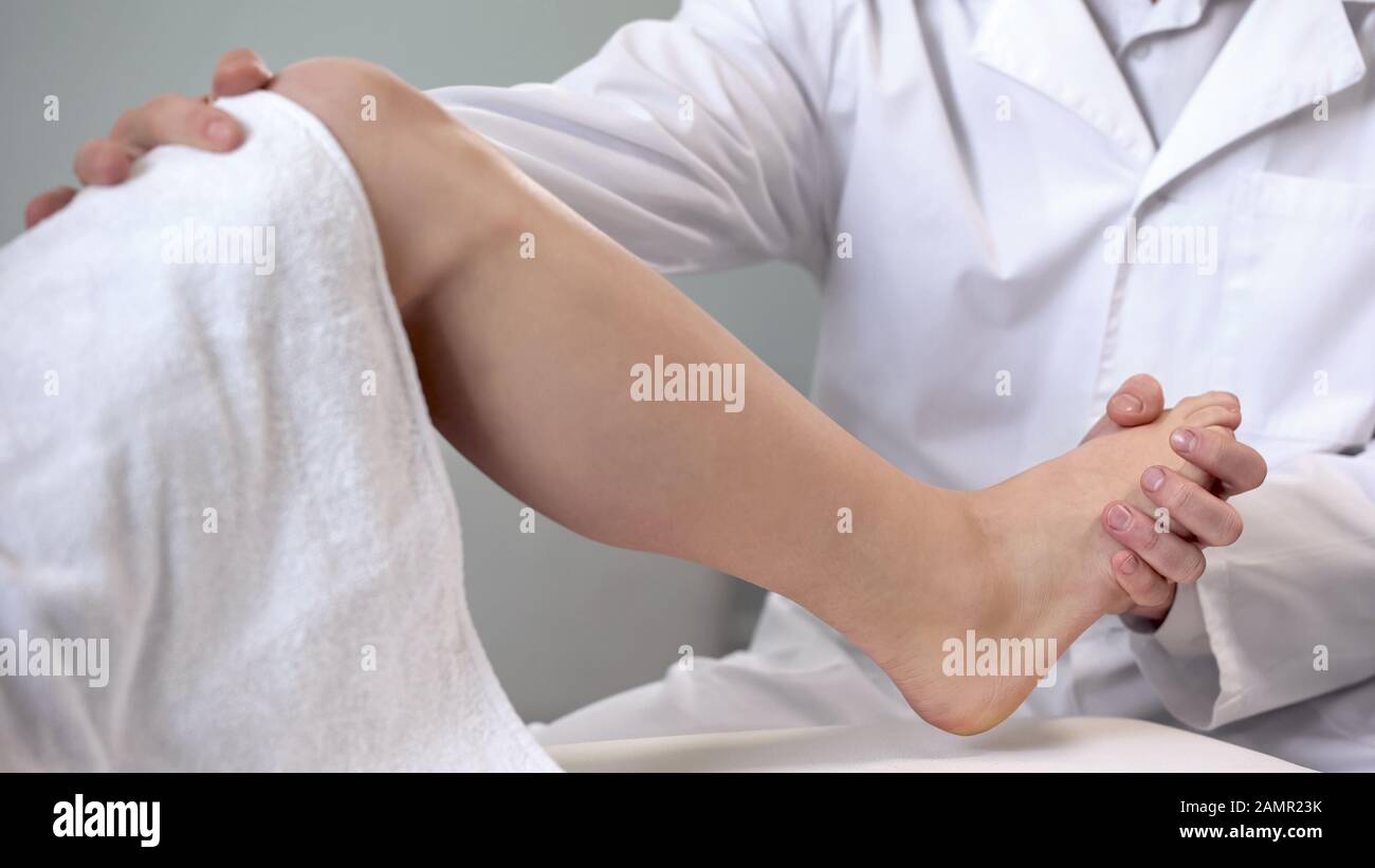 Traumatologist examining patient foot, patient receiving first aid in ...