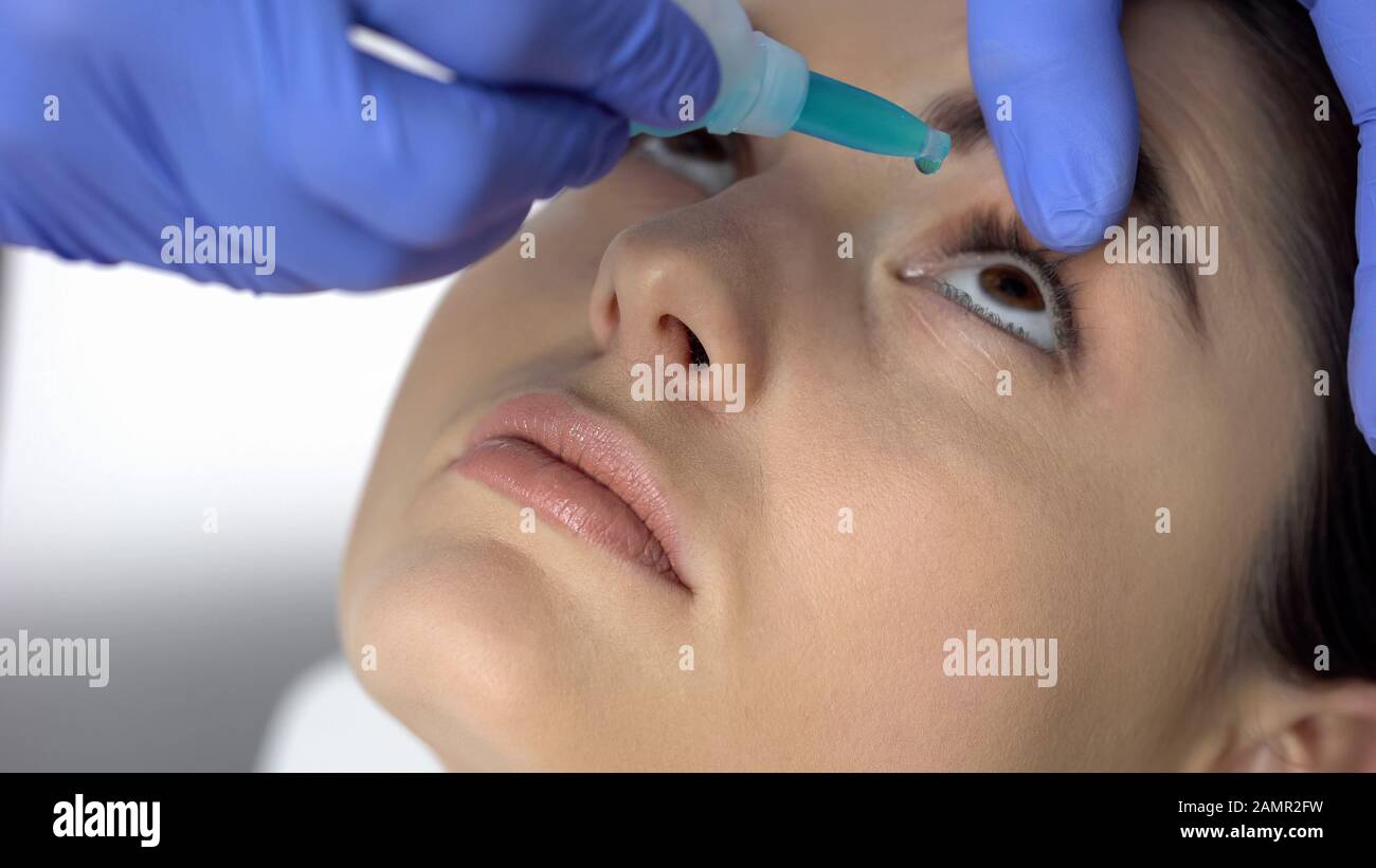 Doctor dripping medicine into patient eyes, eyesight checkup, dryness ...