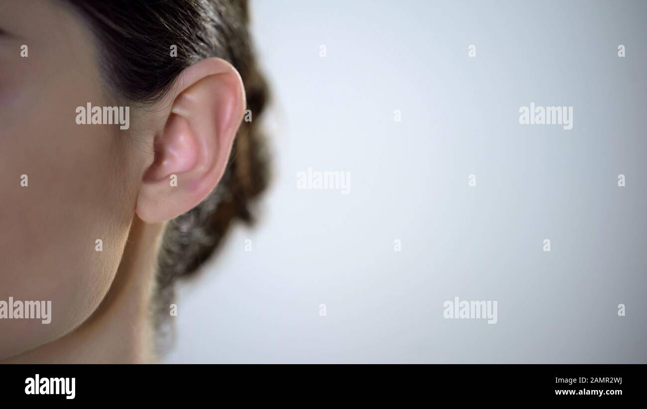 Young female ear closeup, useless rumors and disinformation, privacy ...