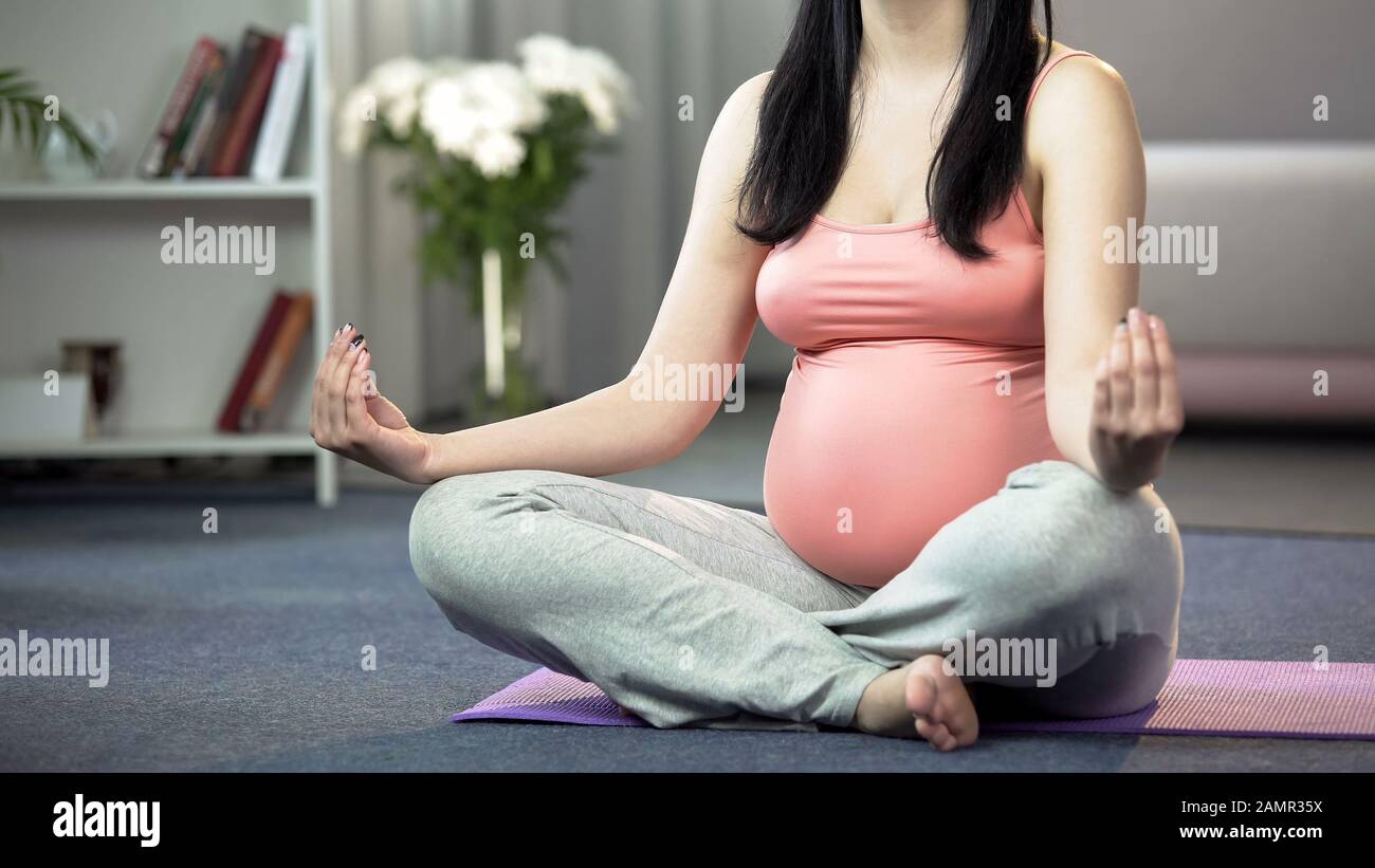 Pregnant doing lotus pose yoga for future mum caring about mental ...