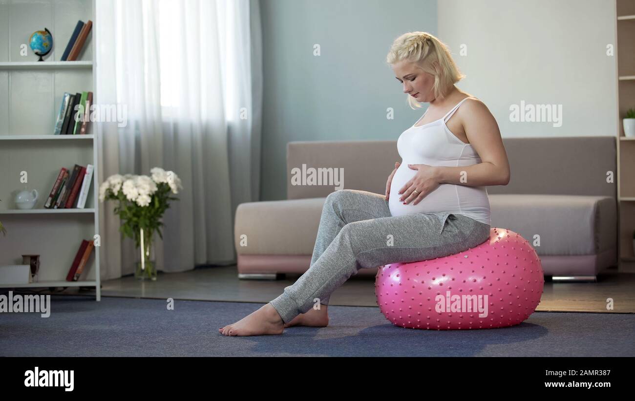 Happy future mother enjoying pregnancy, gently stroking tummy ...