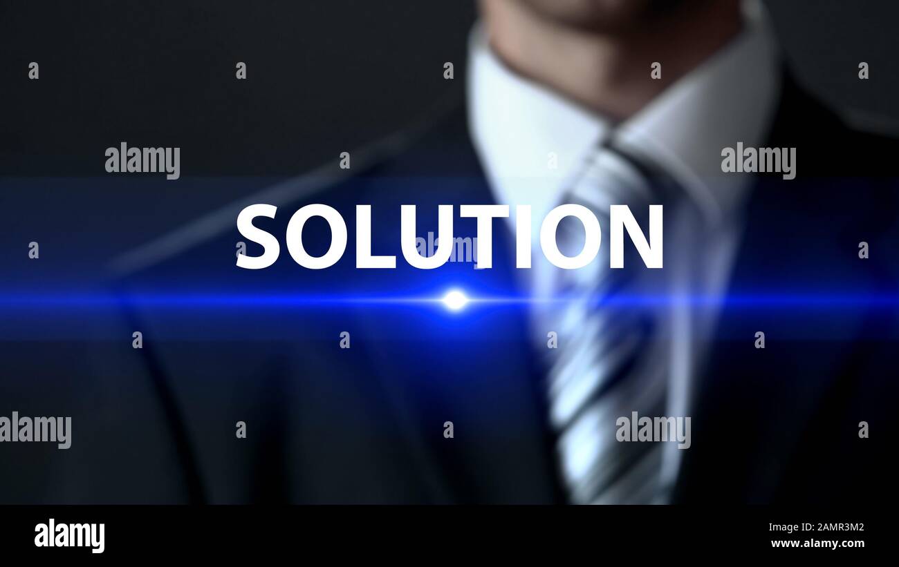 Solution, male wearing business suit standing in front of screen, key ...