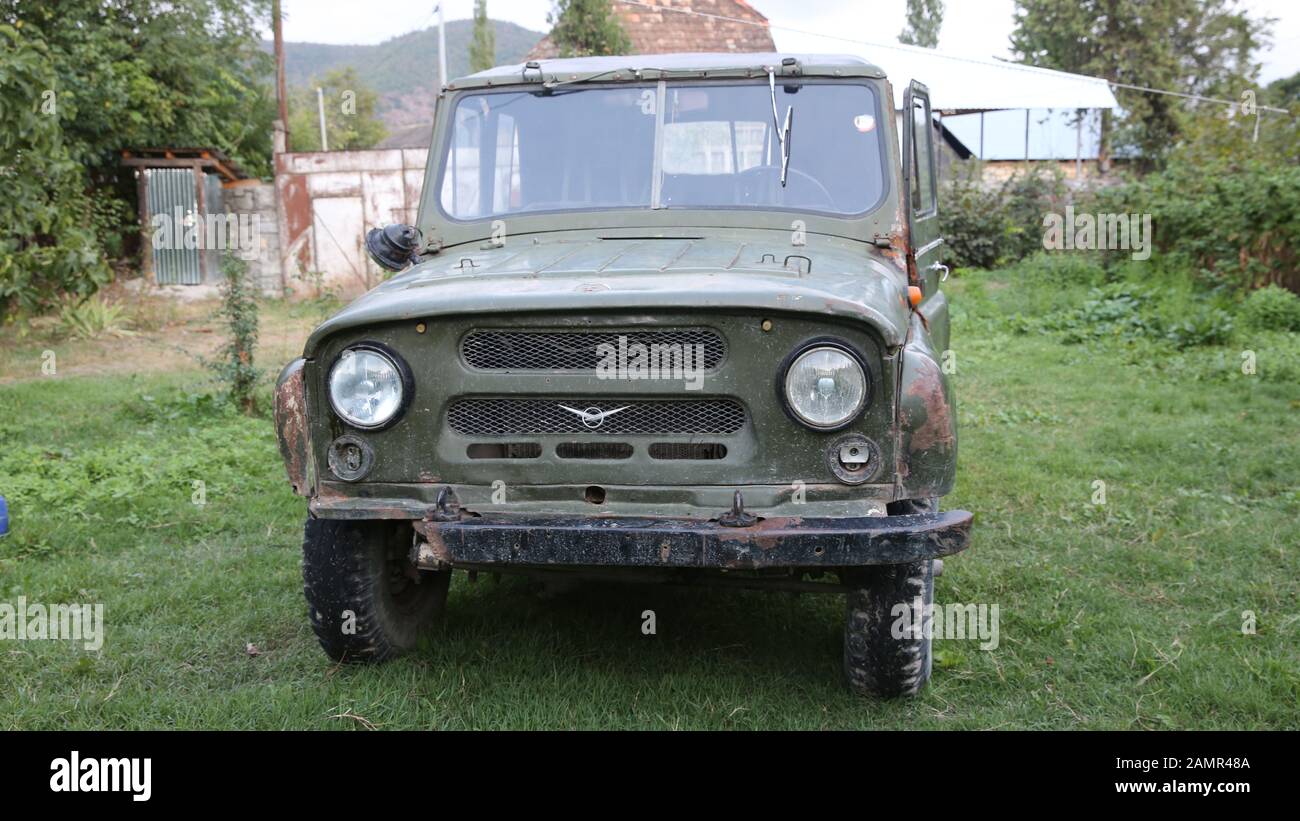 Soviet UAZ SUV on a city street .Glass headlight of an old retro ...