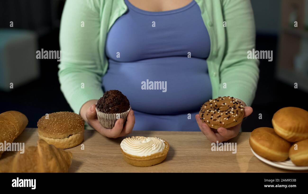 Obese woman holding muffins and donuts, overeating sweets, unhealthy ...