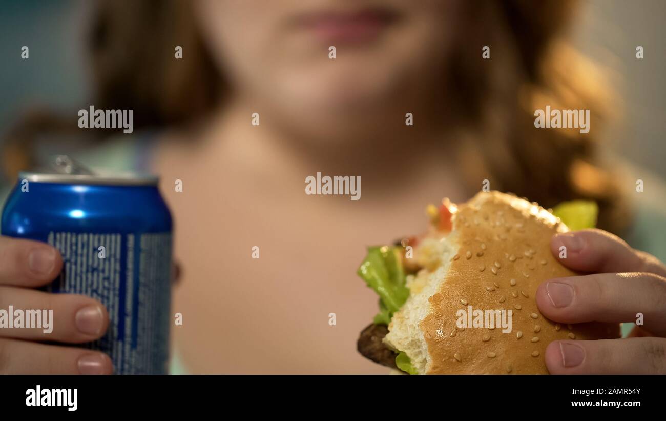 Lady eating junk food and drinking sugary soda from can, overeating ...