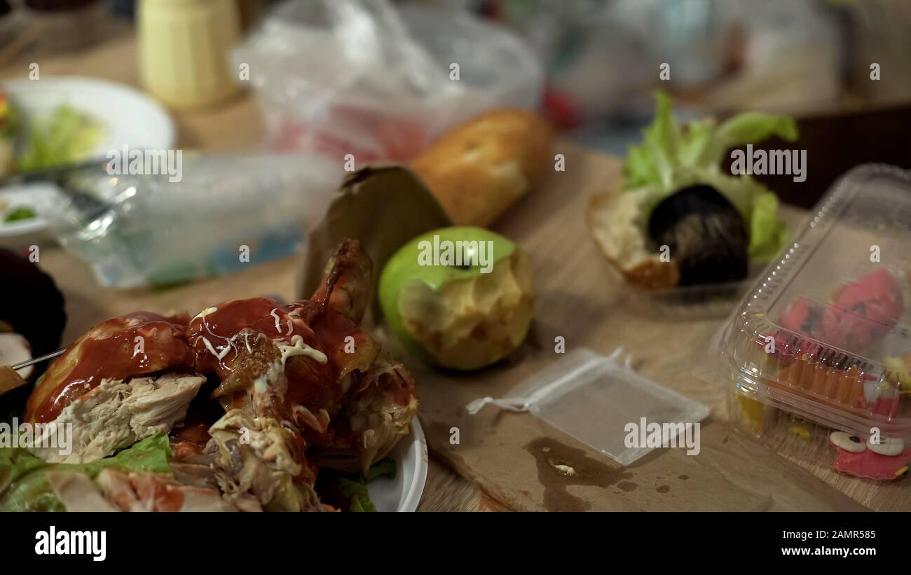 Messy table with dirty plates full of fatty unhealthy food leftovers ...