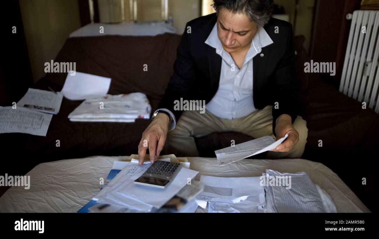 Male houseowner checking mail and bills, thoroughly counting cost of ...