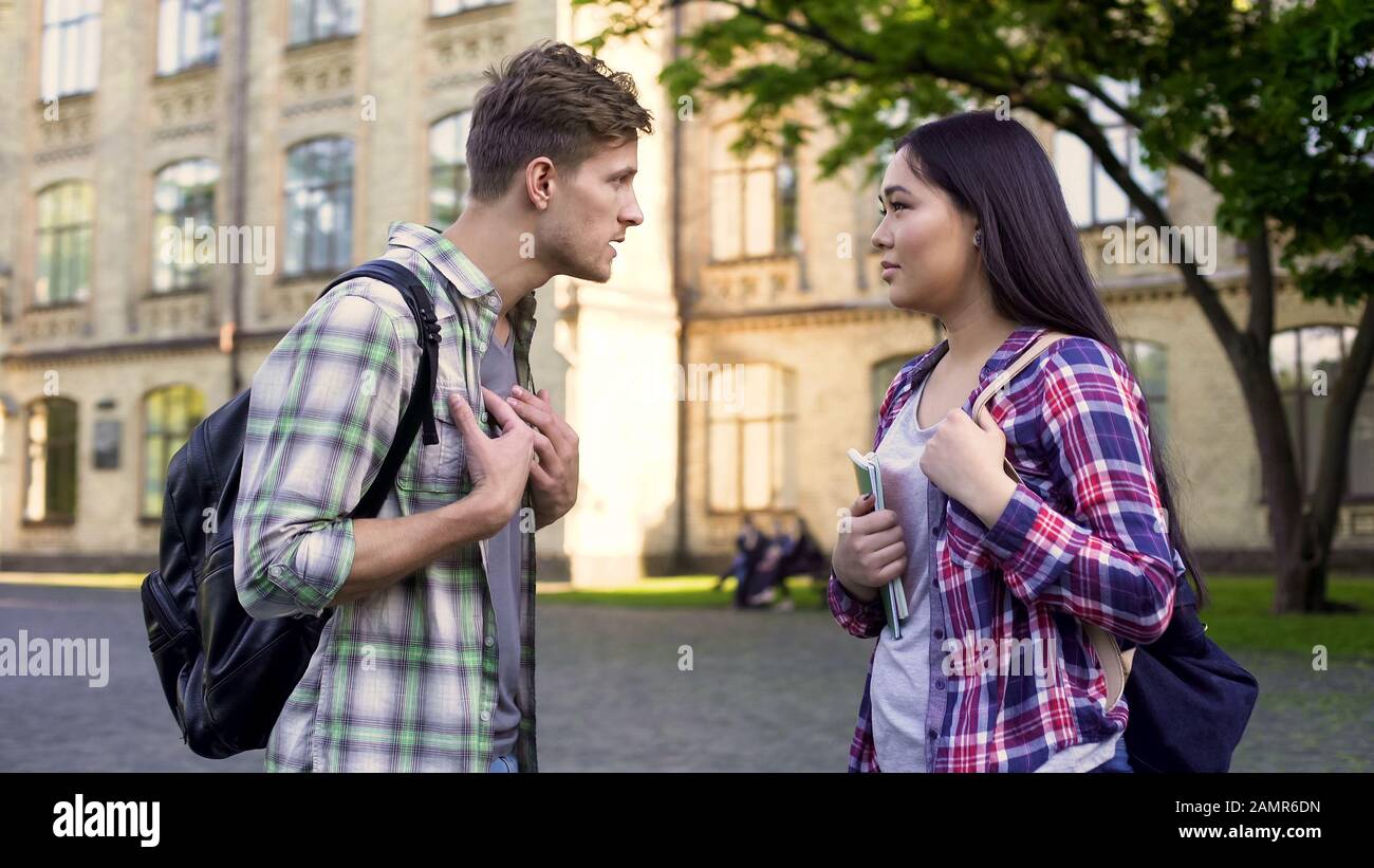 Emotional male student talking with ex-girlfriend near university ...