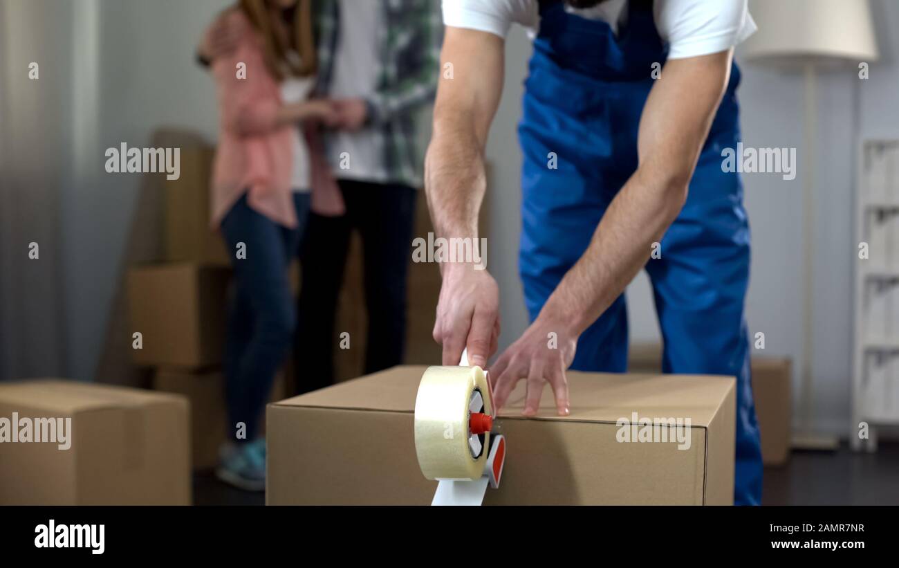 Couple sadly watching worker taking away their things, confiscation of ...