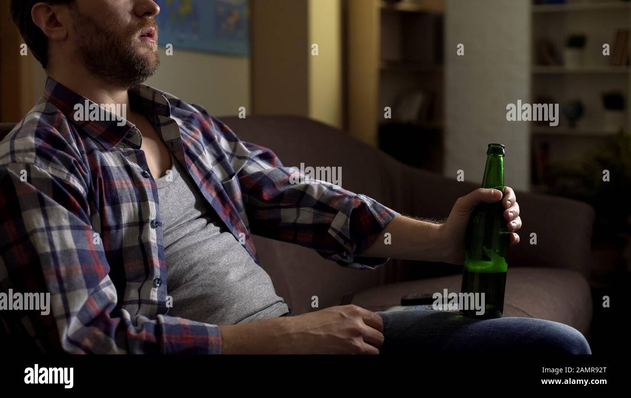 Wasted guy sitting on couch, drinking beer, alcoholism, psychological ...