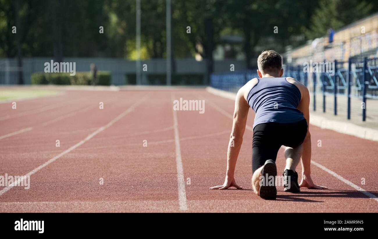 Athlete in starting position to run on stadium, professional sportsman ...