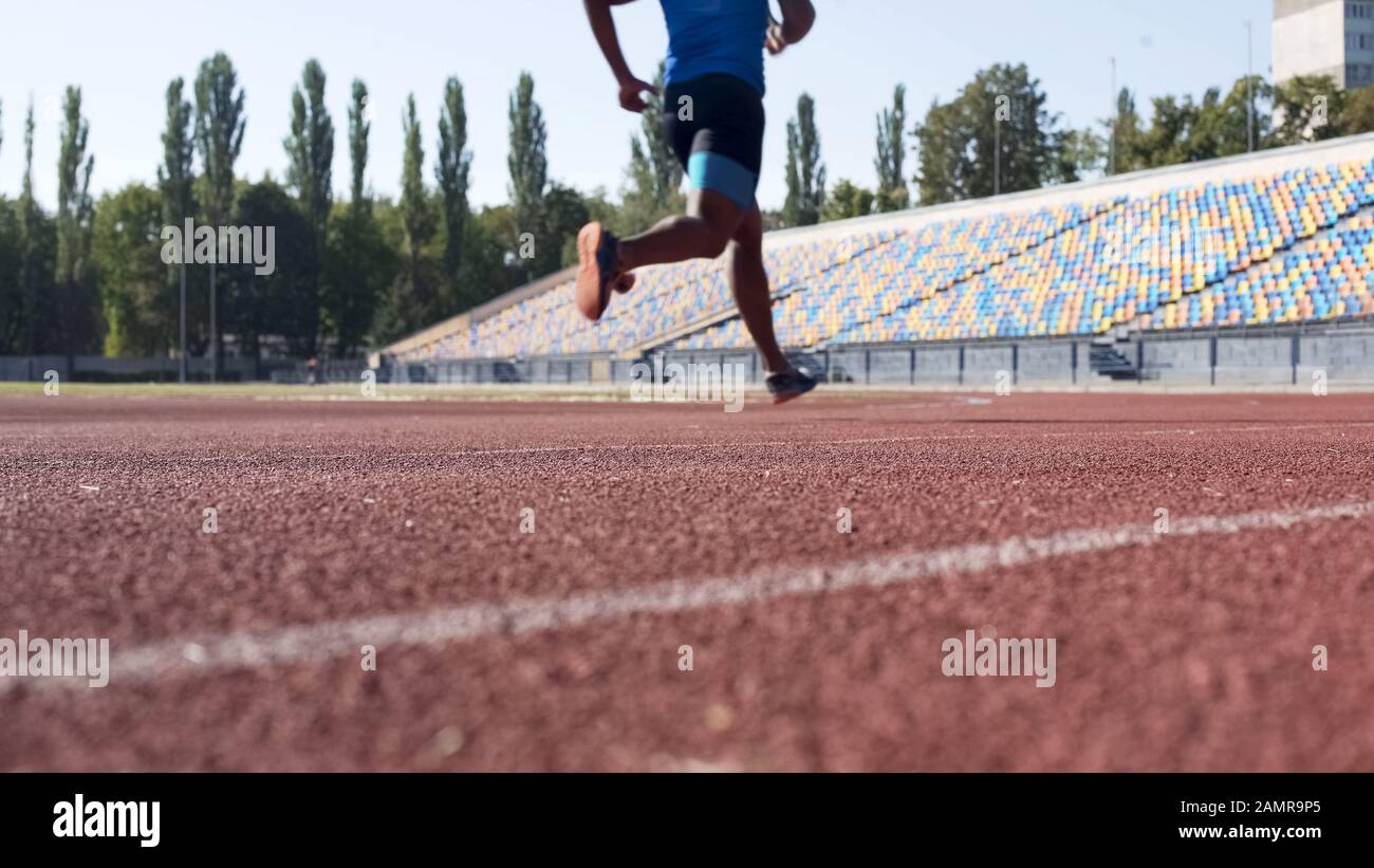 Athletic guy running at stadium, preparing for competition, daily ...