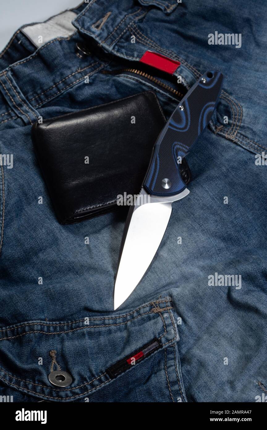 Blue pocket knife and jeans. Casual clothes and knife. Vertical frame ...