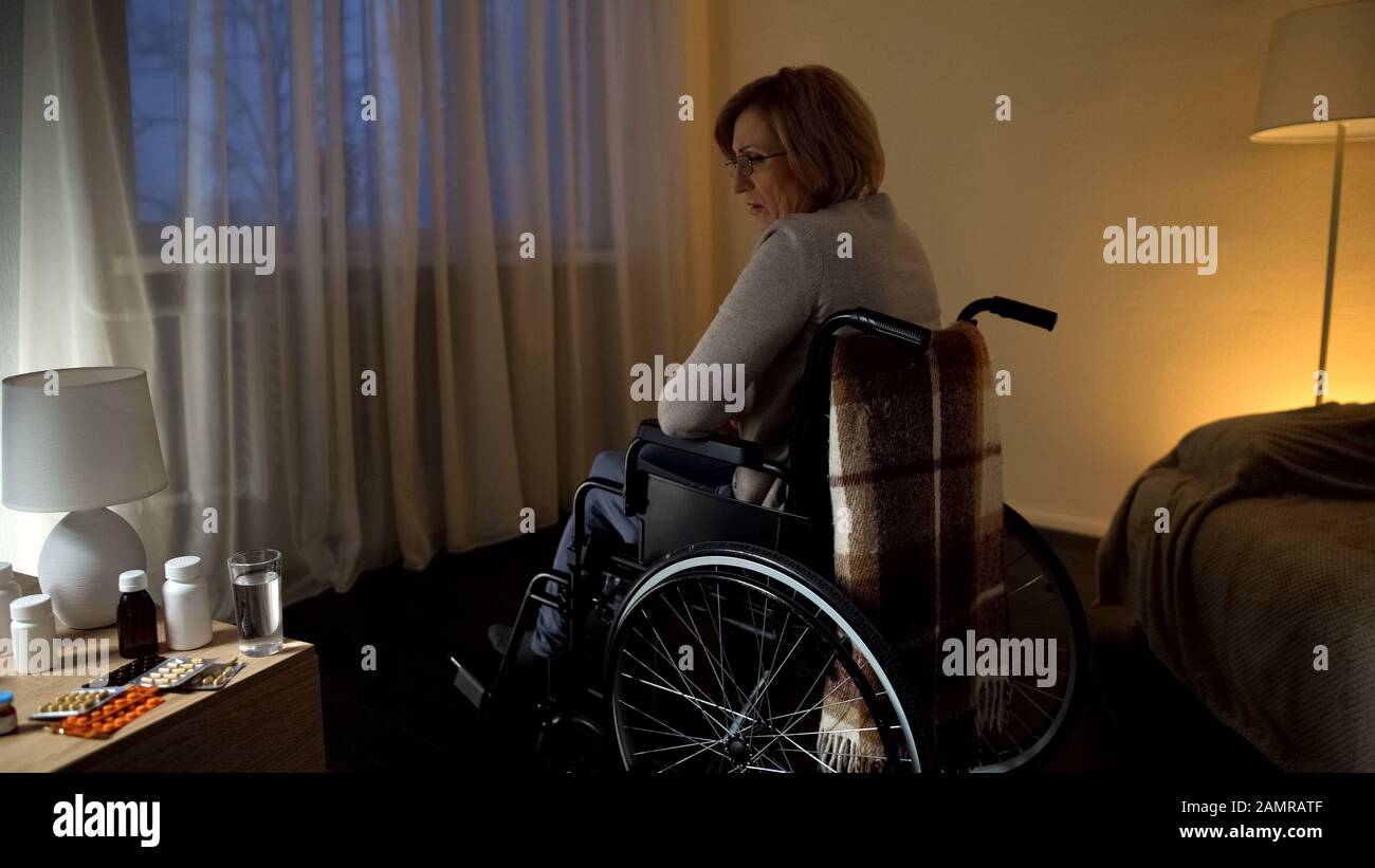 Disabled lady feeling lonely sitting near window, loneliness and ...