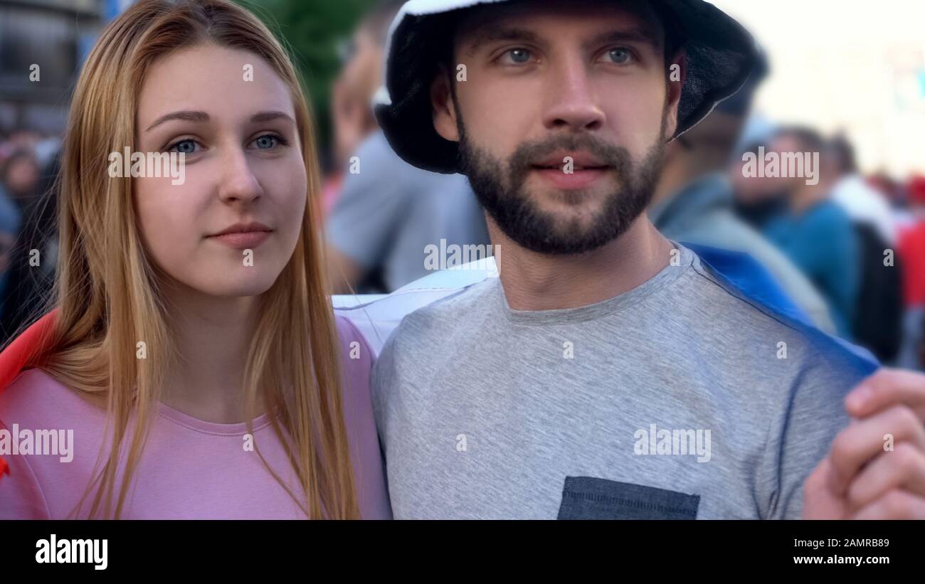 Excited football team supporters waiting for game outdoors, looking at ...