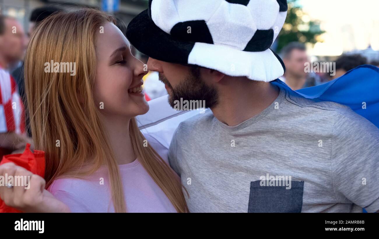 Cheerful football fans couple kissing in crowd, rejoicing goal of ...