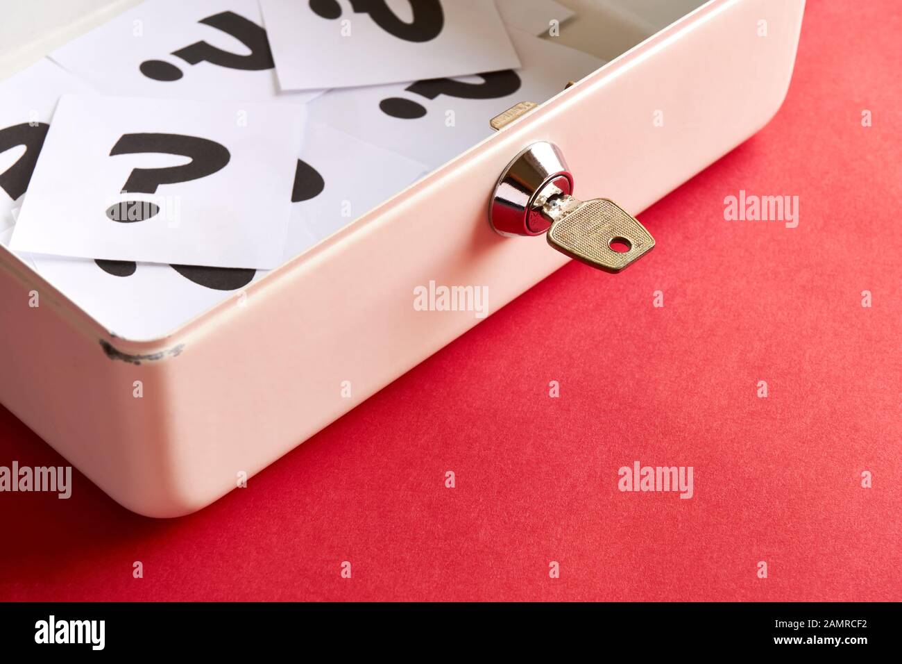 Close up of small white open cashbox or money box with question marks ...