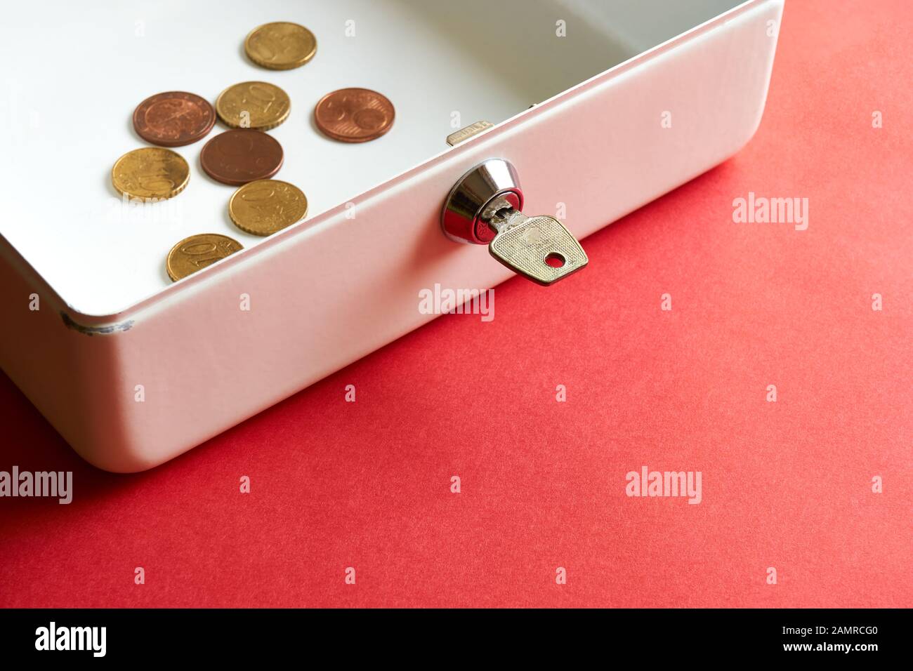 Close up of small white open cashbox or money box with euro coins ...