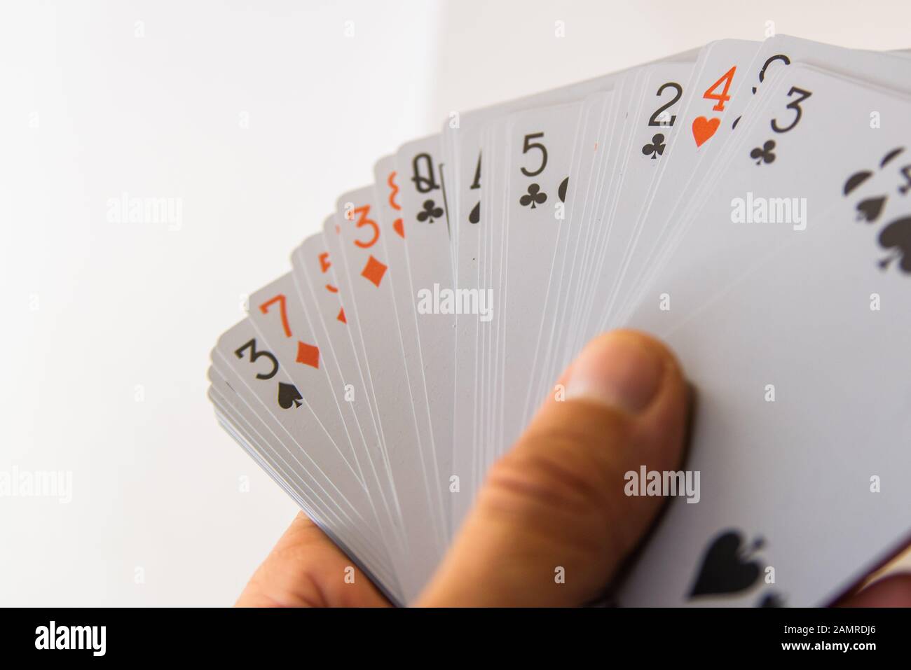 Playing cards in hand isolated on white background Stock Photo - Alamy