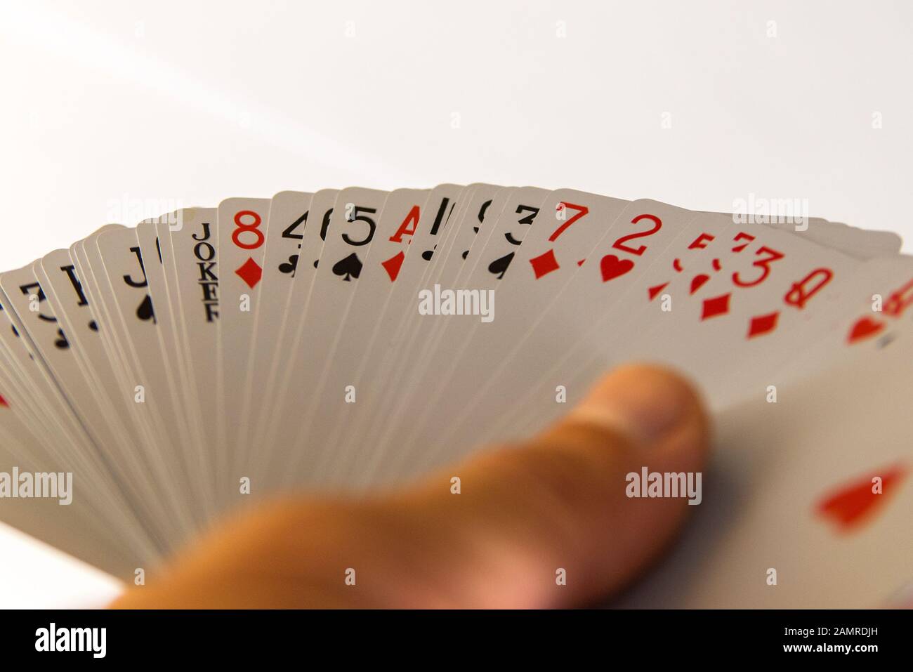 Playing cards in hand isolated on white background Stock Photo - Alamy
