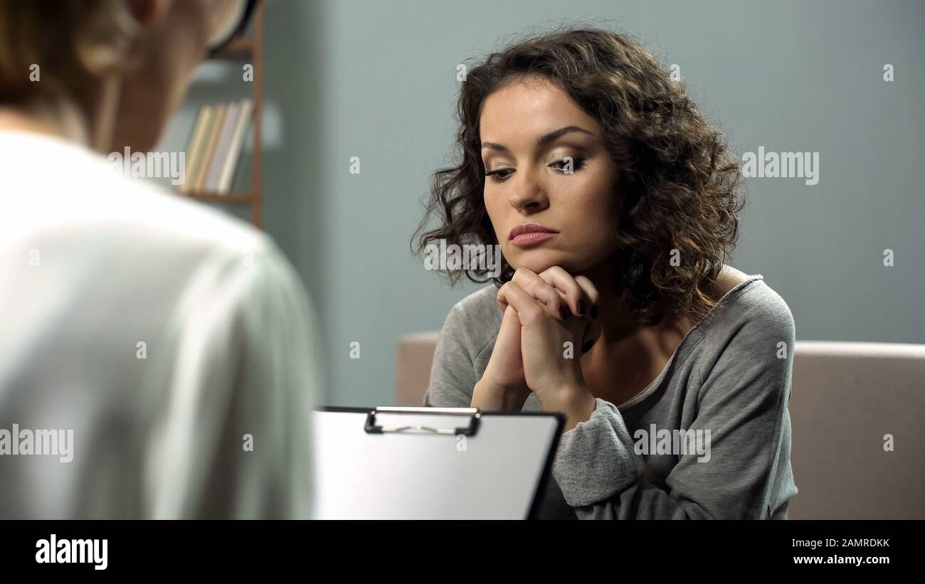 Hopeless young lady listening to psychologist attending personal ...