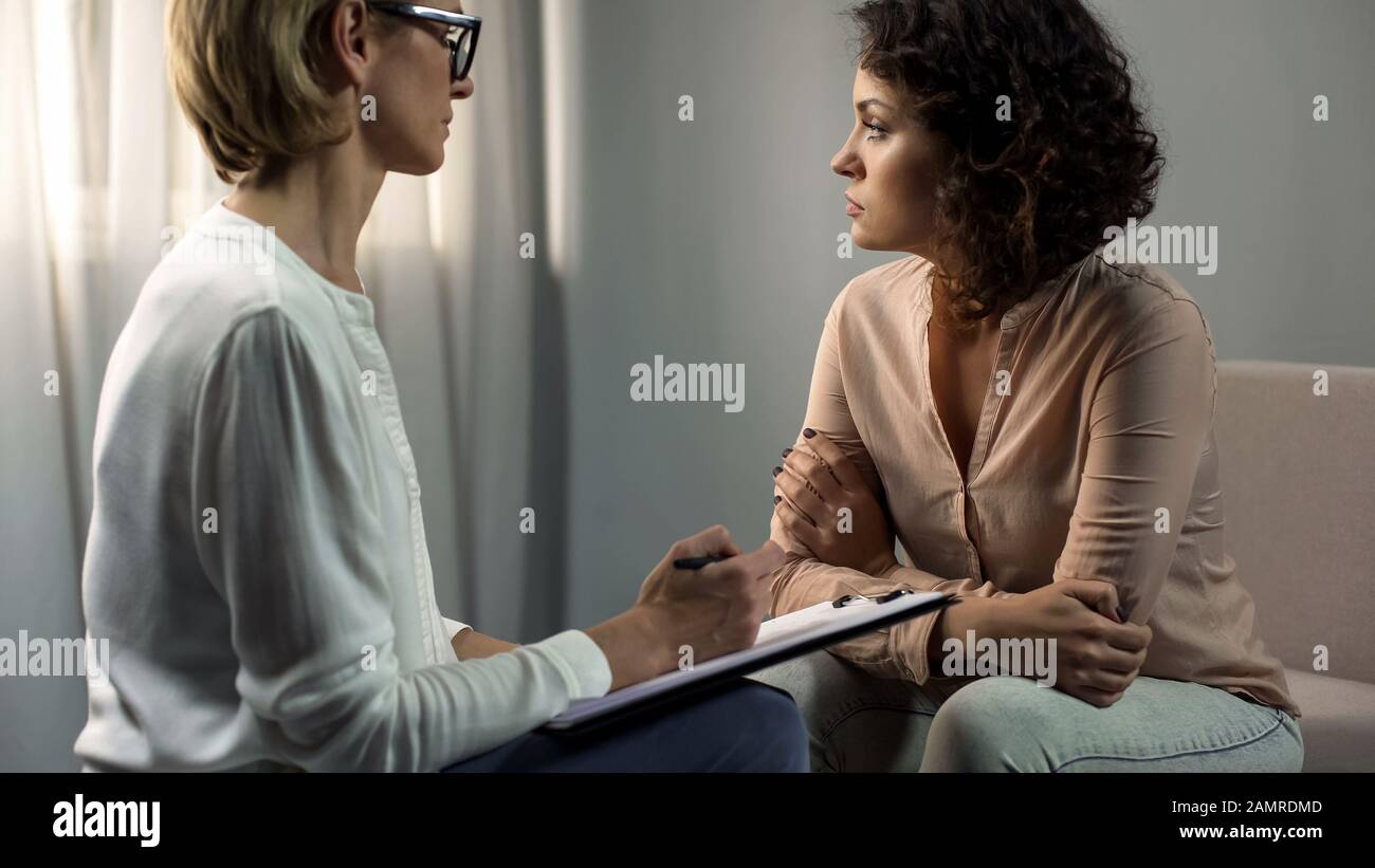 Professional psychologist listening depressed lady patient, break-up ...