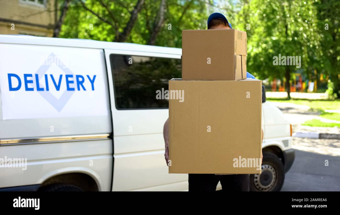 Delivery workman holding many cardboard boxes, express parcel shipment ...