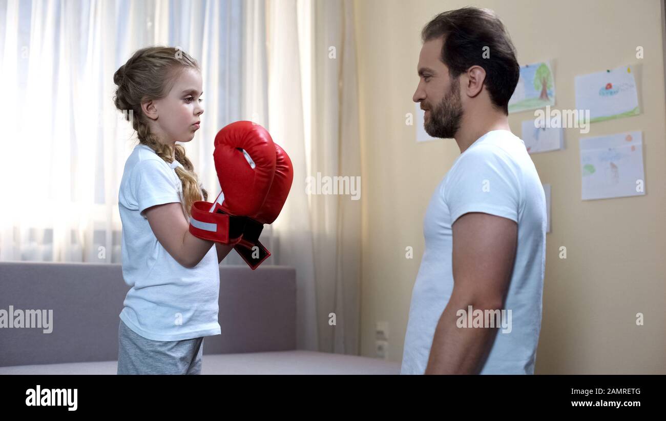 Beautiful daughter in boxing gloves standing in front of dad, self ...