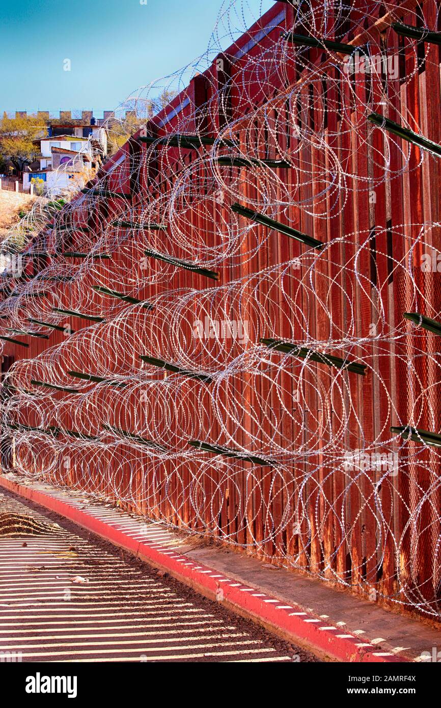 The US-Mexican border wall with layers of razor wire at Nogales AZ ...