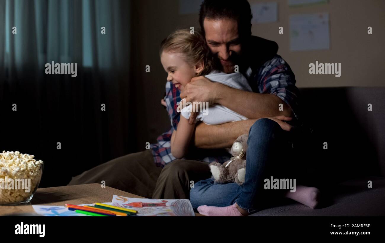 Playing video game, father daughter hugging after winning round, gadget ...