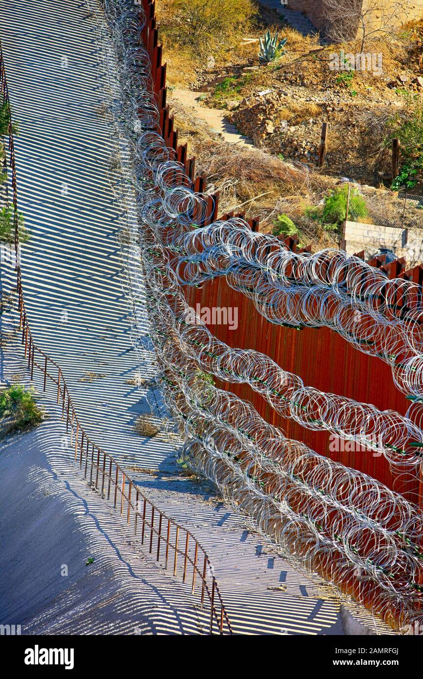 The US-Mexican border wall with layers of razor wire at Nogales AZ ...