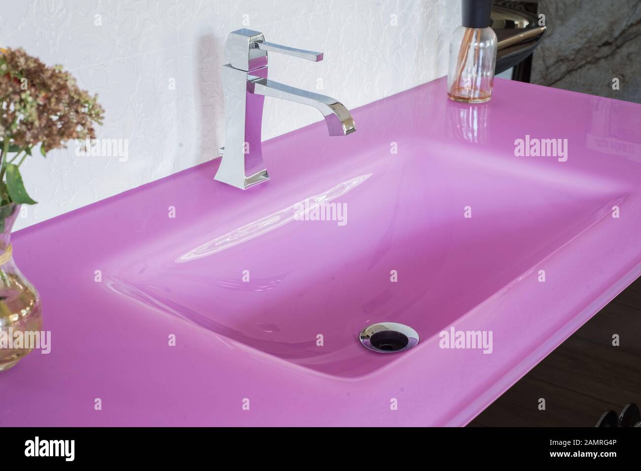 Closeup of a pink stone of a glossy washbasin, in a fashionable ...