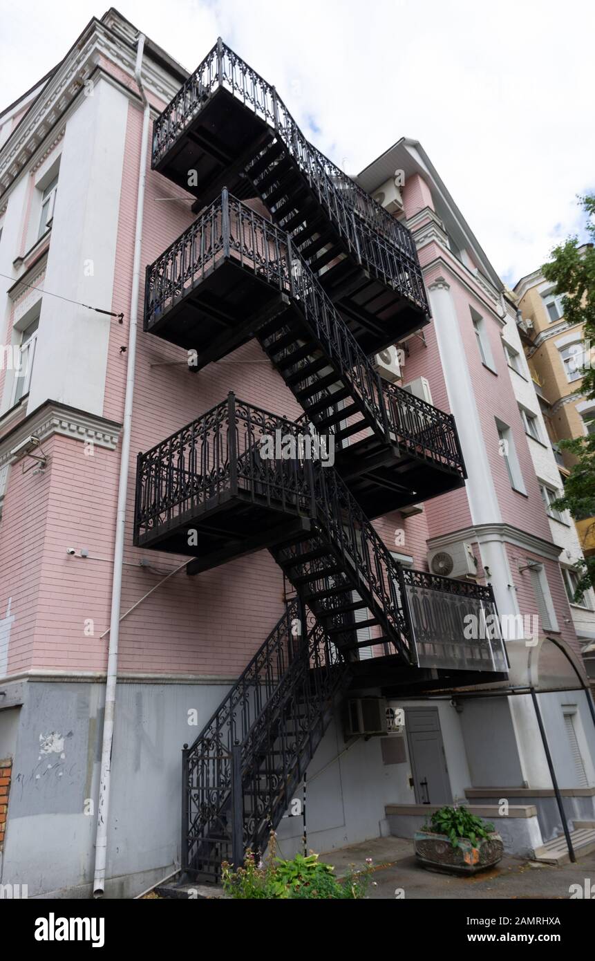 Fire escape leading to the roof. Black iron staircase. Emergency exit ...