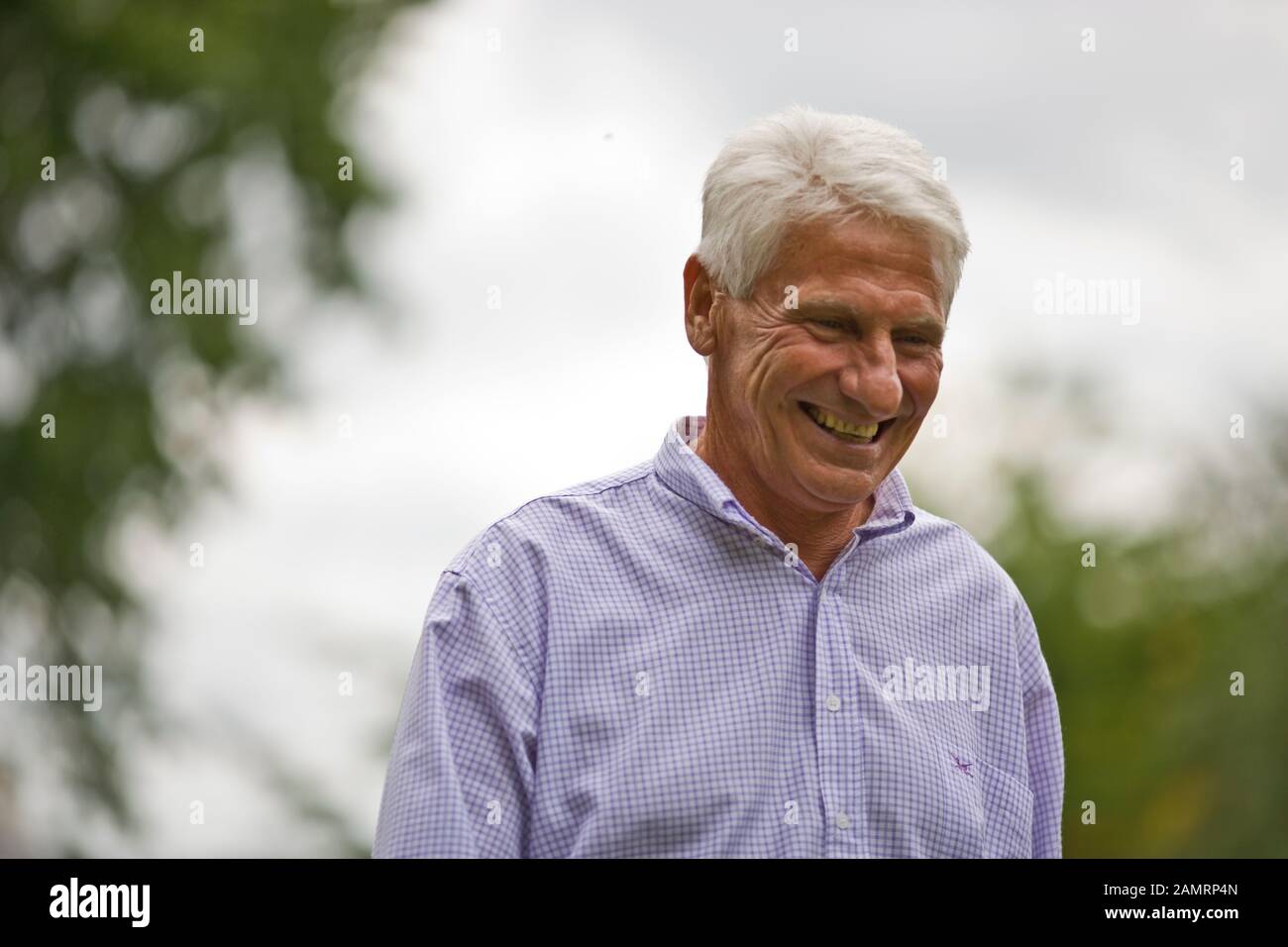 Smiling senior adult man standing outside in the garden Stock Photo - Alamy