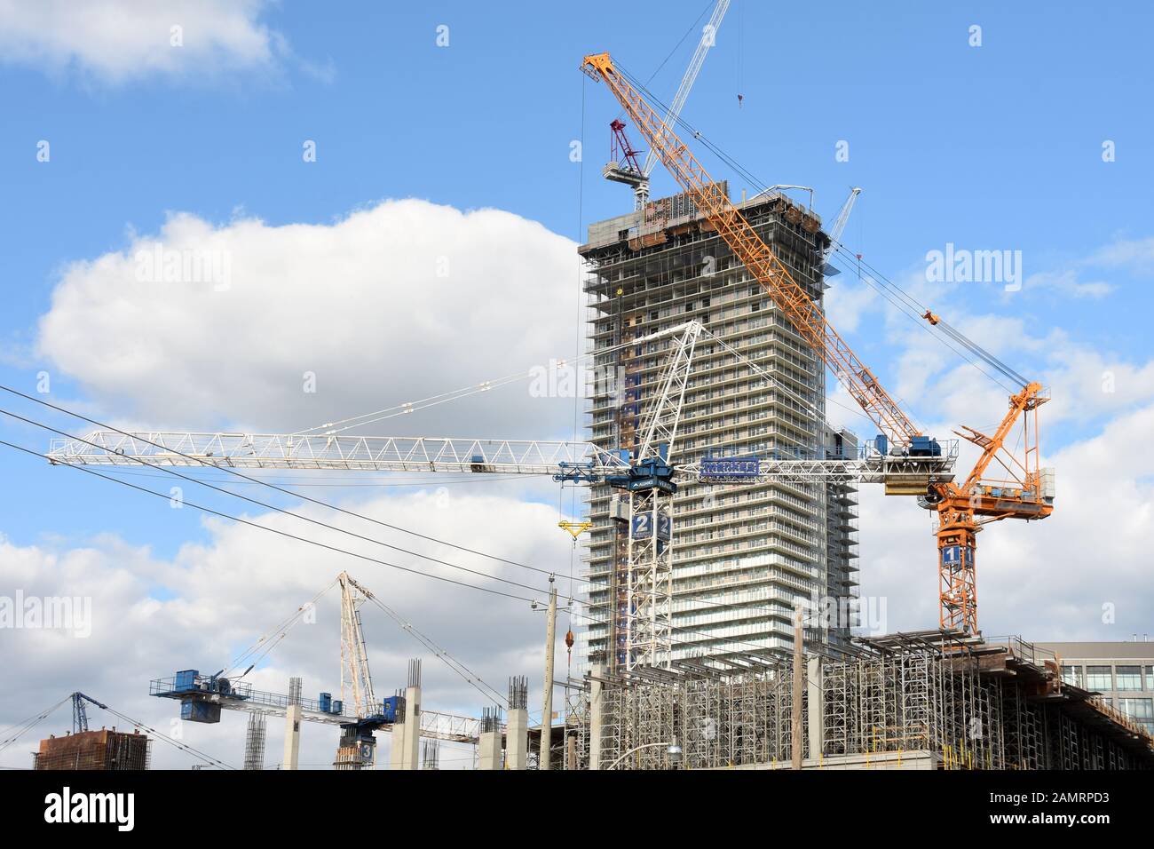 Construction site with cranes on top of an office or apartment tower in ...