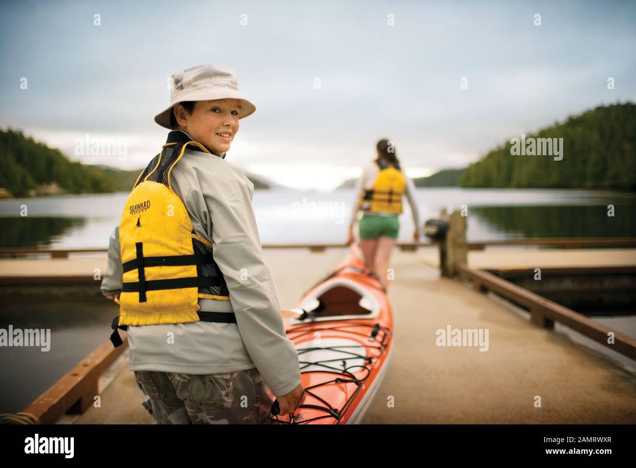 teenage boy carries a kayak Stock Photo - Alamy