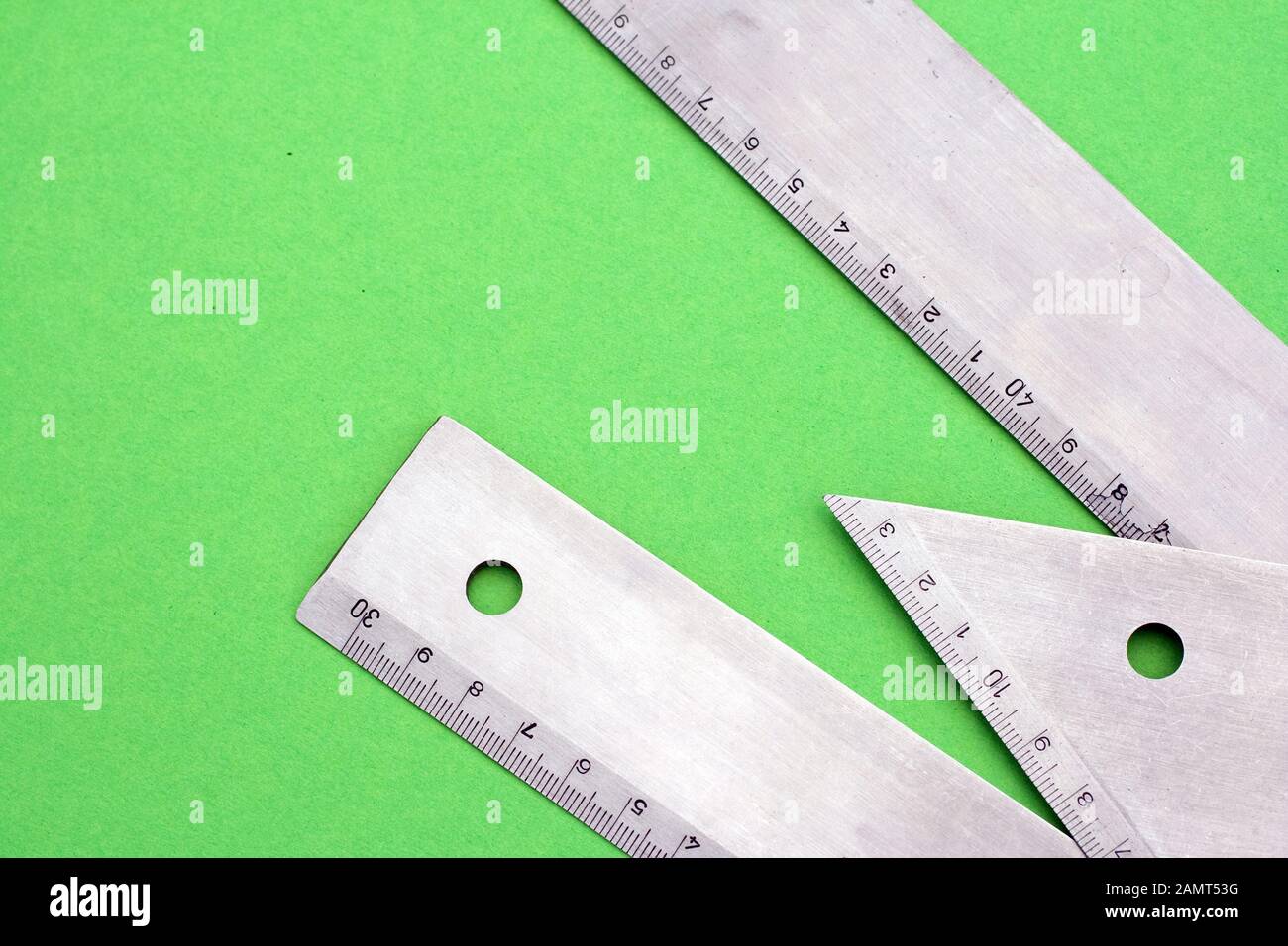 Rulers and tools on green background Stock Photo - Alamy